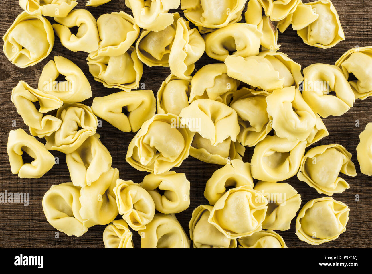 Raw tortellini pasta flatlay on brown wood background Italian ...