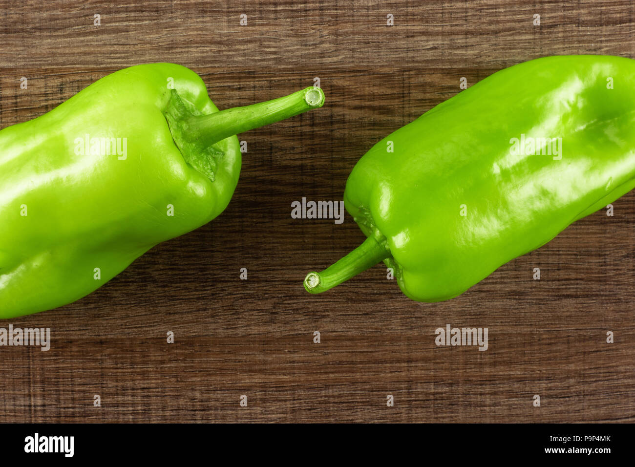 Group of two whole light green bell pepper flatlay isolated on brown ...