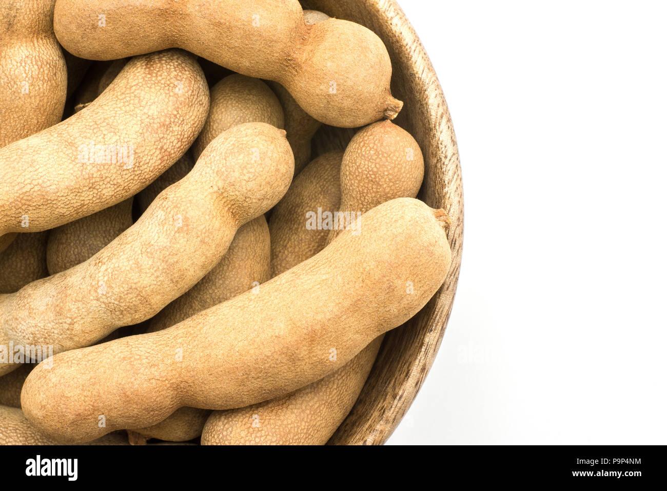 Indian dates tamarind in a wooden bowl top view isolated on white ...