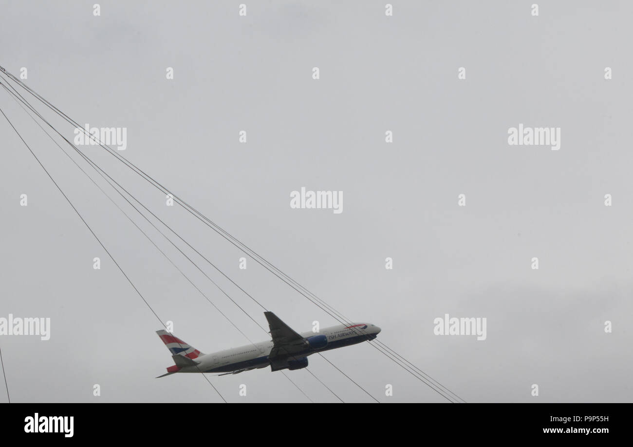 The Boeing 777-200 of British Airways pictured through electrical wires ...
