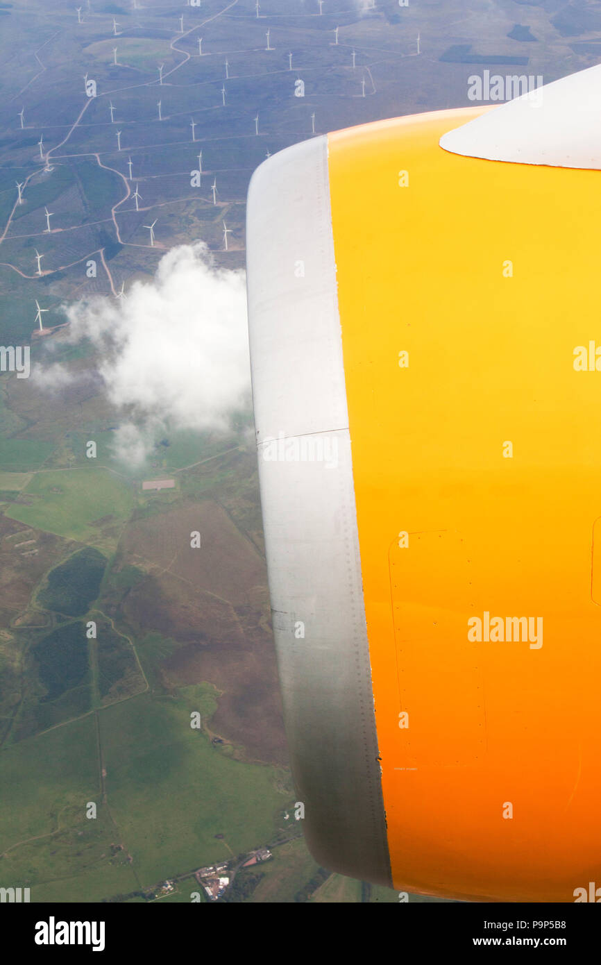 Jet engine of airplane flying over wind farm, Scotland, UK Stock Photo ...