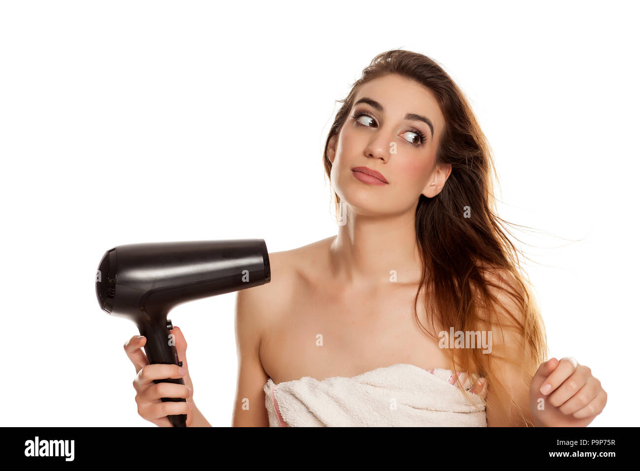 young beautiful woman drying her hair with a blow dryer on a white ...