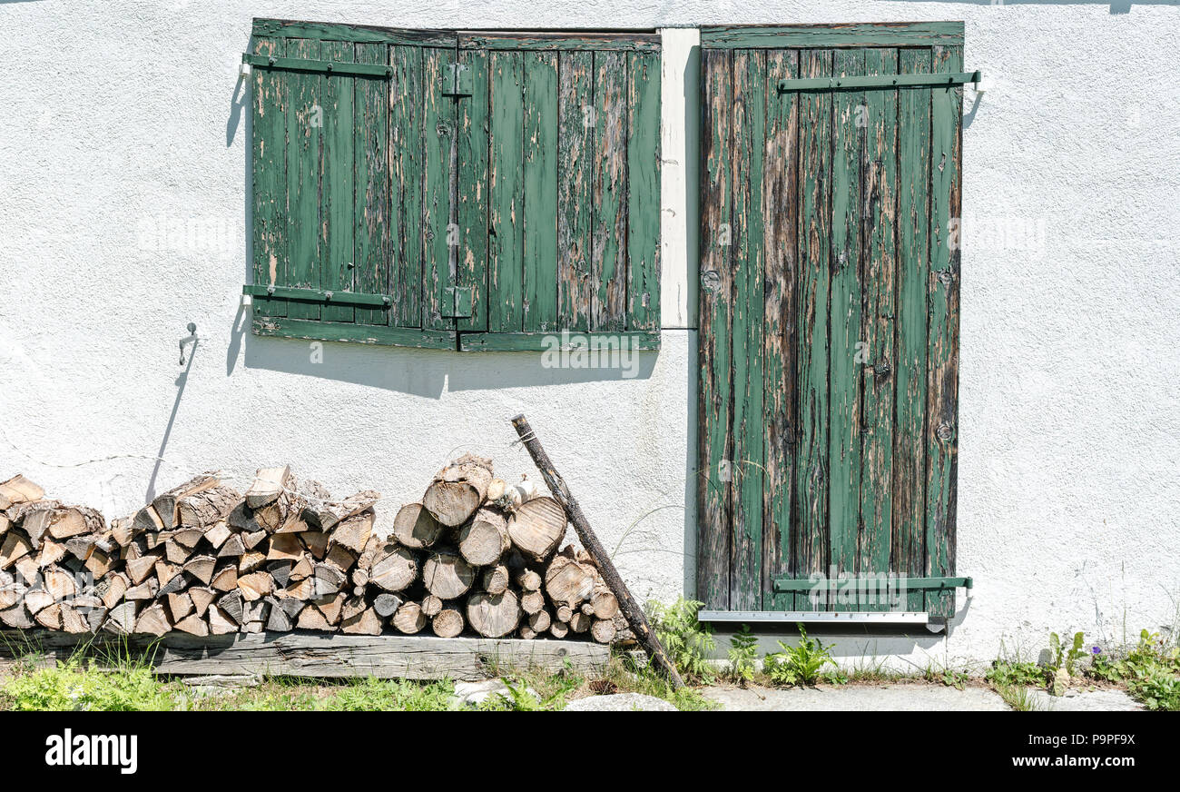 close up of a house front with rustic wooden green window shutters and ...
