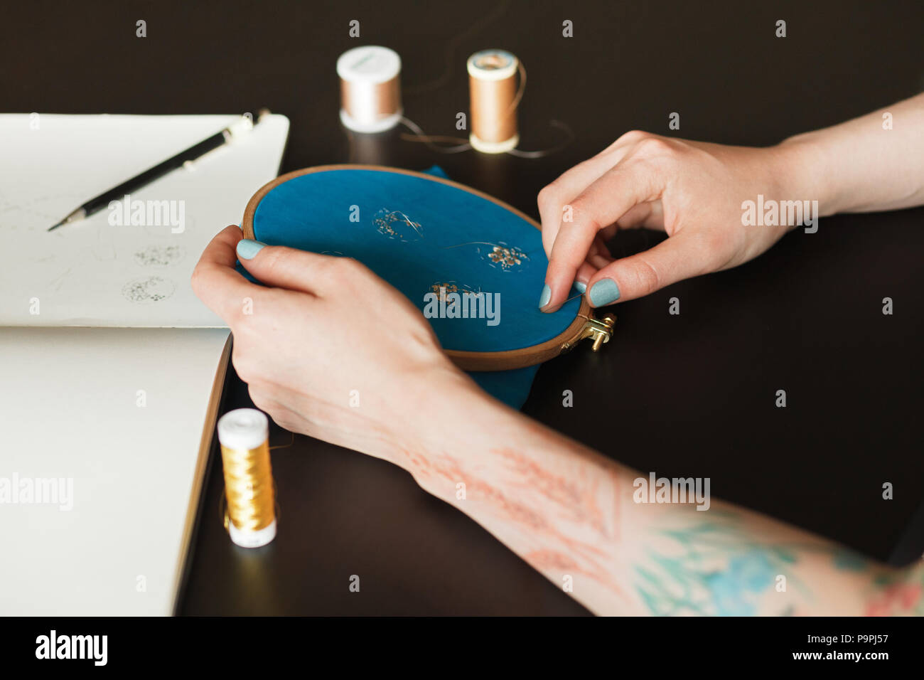 Workplace embroiderers: outline in a notepad, embroidery hoop, scissors ...