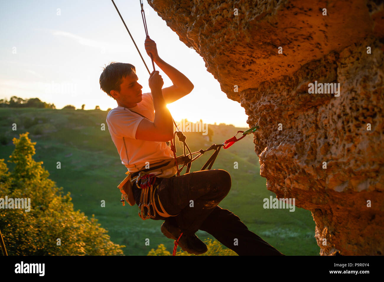 Picture of man clambering over rock Stock Photo - Alamy