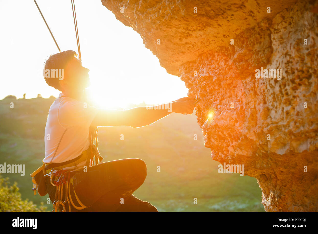 Picture of man clambering over rock Stock Photo - Alamy