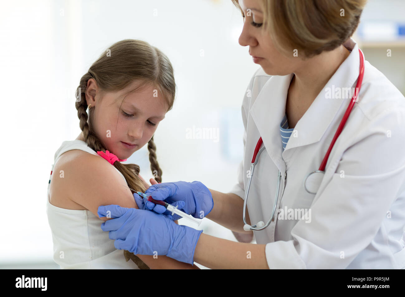 Doctor give injection to girl's arm Stock Photo - Alamy