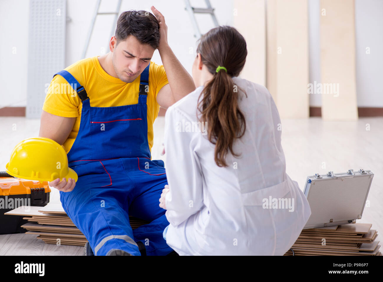 Doctor helping injured worker at construction site Stock Photo - Alamy