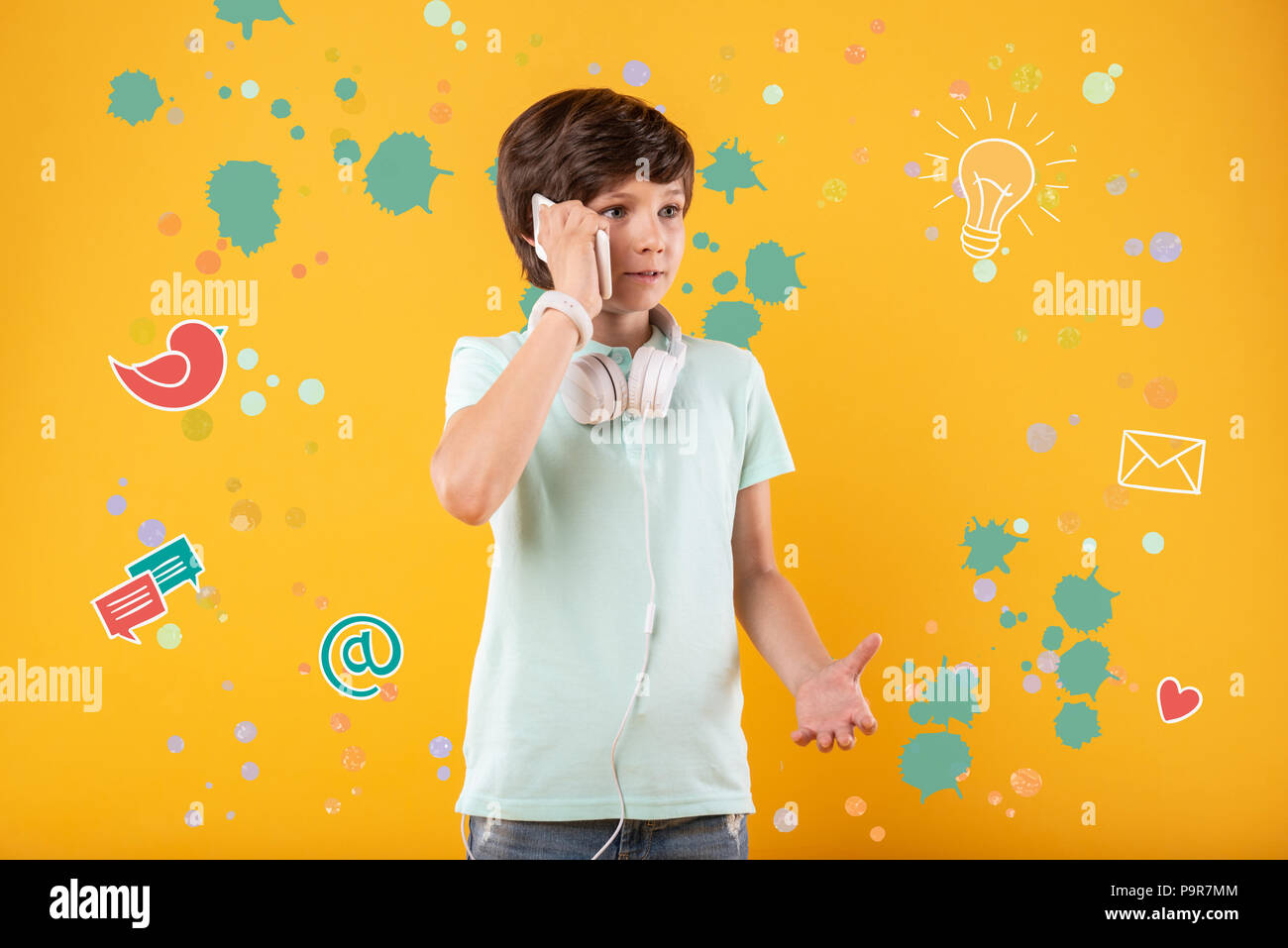 Emotional boy wearing headphones and talking on the phone Stock Photo ...
