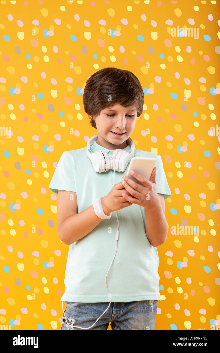 Clever boy feeling interested while using a new smartphone Stock Photo ...