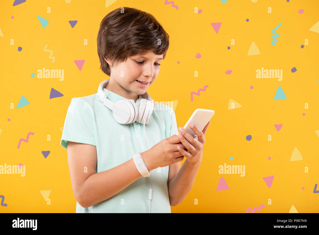 Pretty child holding a smartphone and sending messages Stock Photo - Alamy