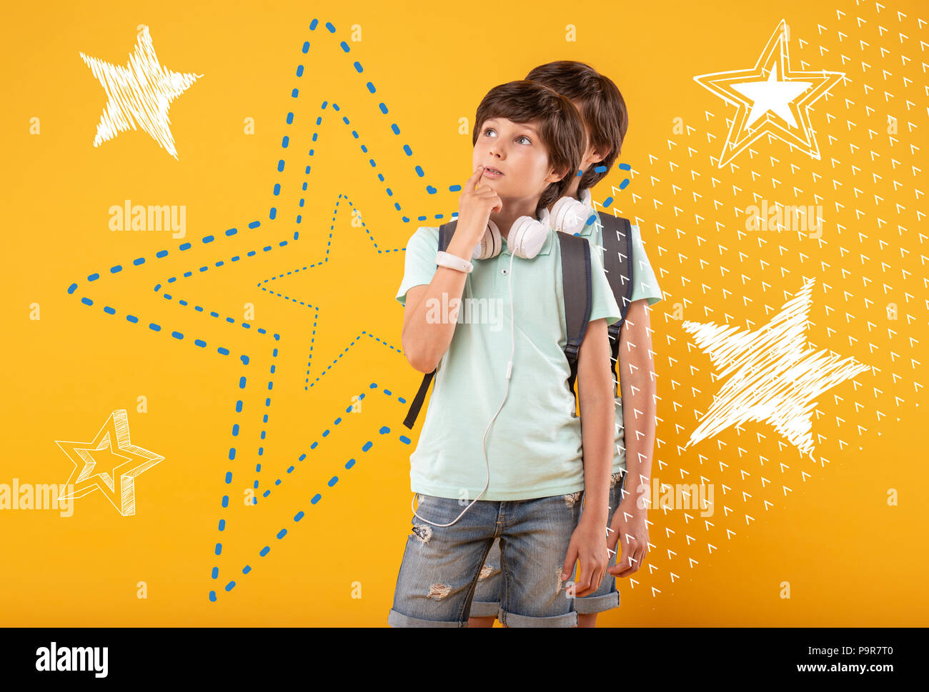 Calm boy touching his lips and thinking Stock Photo - Alamy