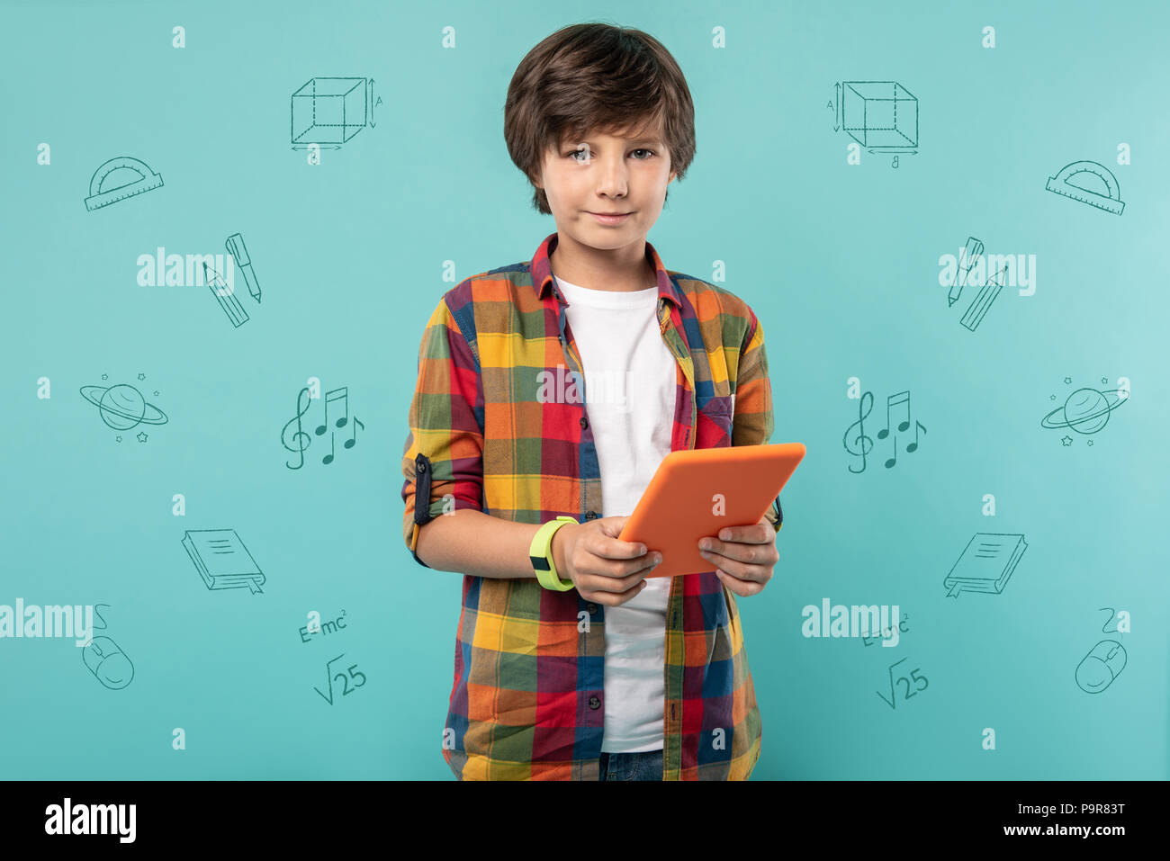 Clever boy using a tablet while studying Stock Photo - Alamy