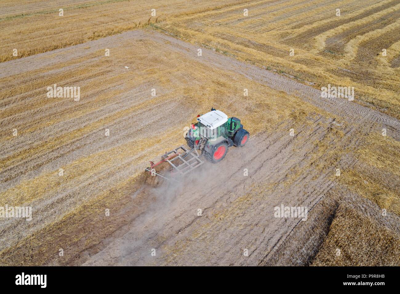 Tractor plowing field after harvesting. Farm works Stock Photo - Alamy