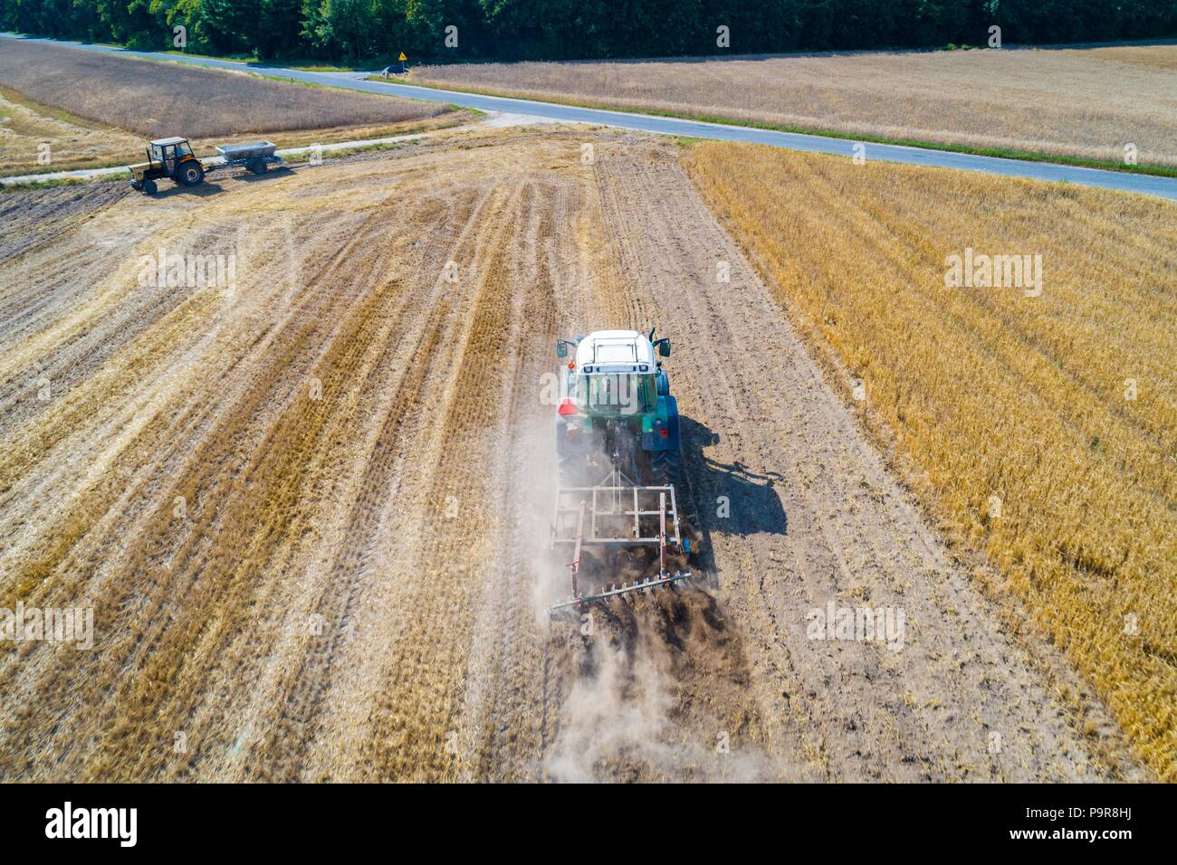 Tractor plowing field after harvesting. Farm works Stock Photo - Alamy