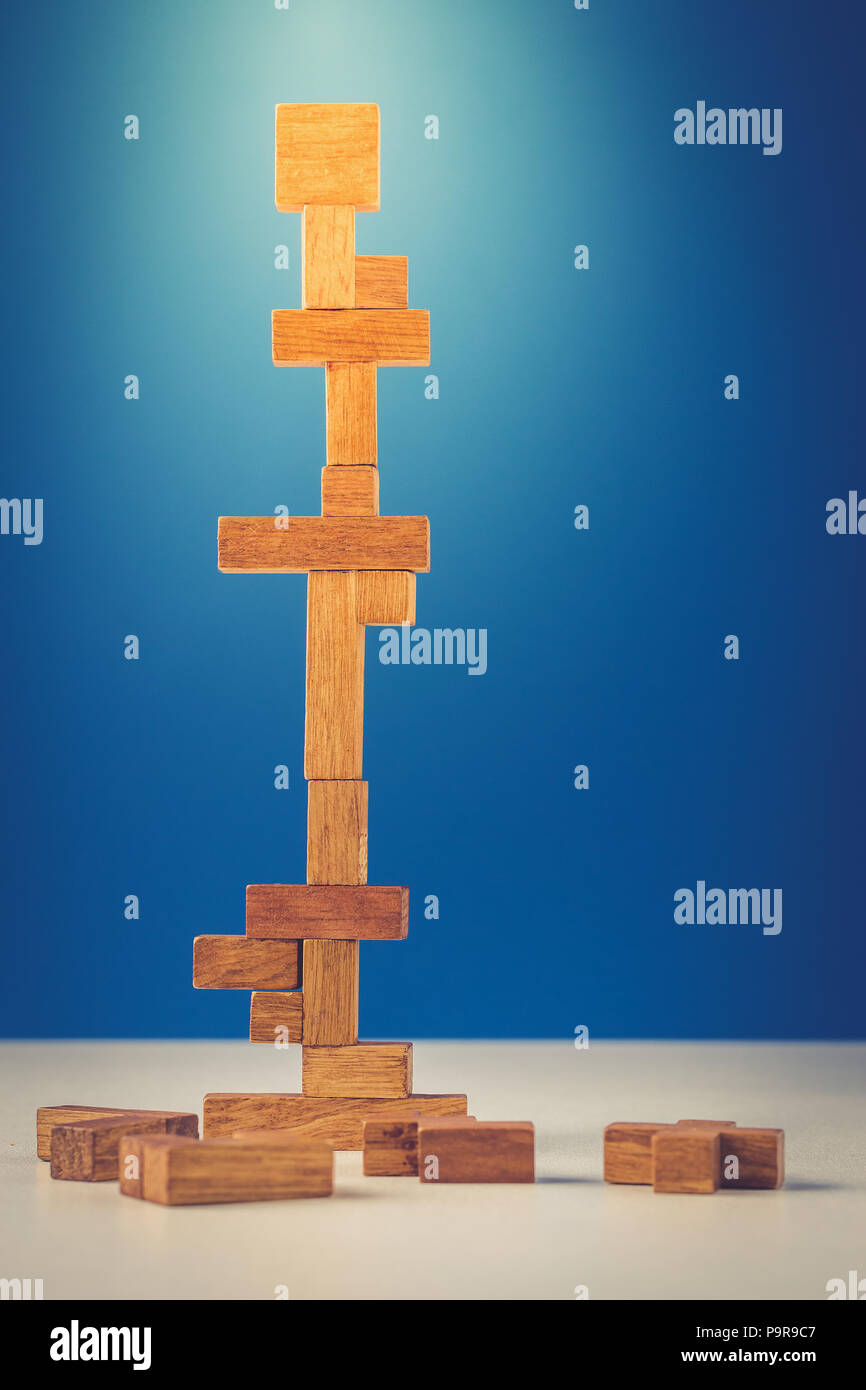 High tower of different shapes wooden blocks on a blue background Stock ...