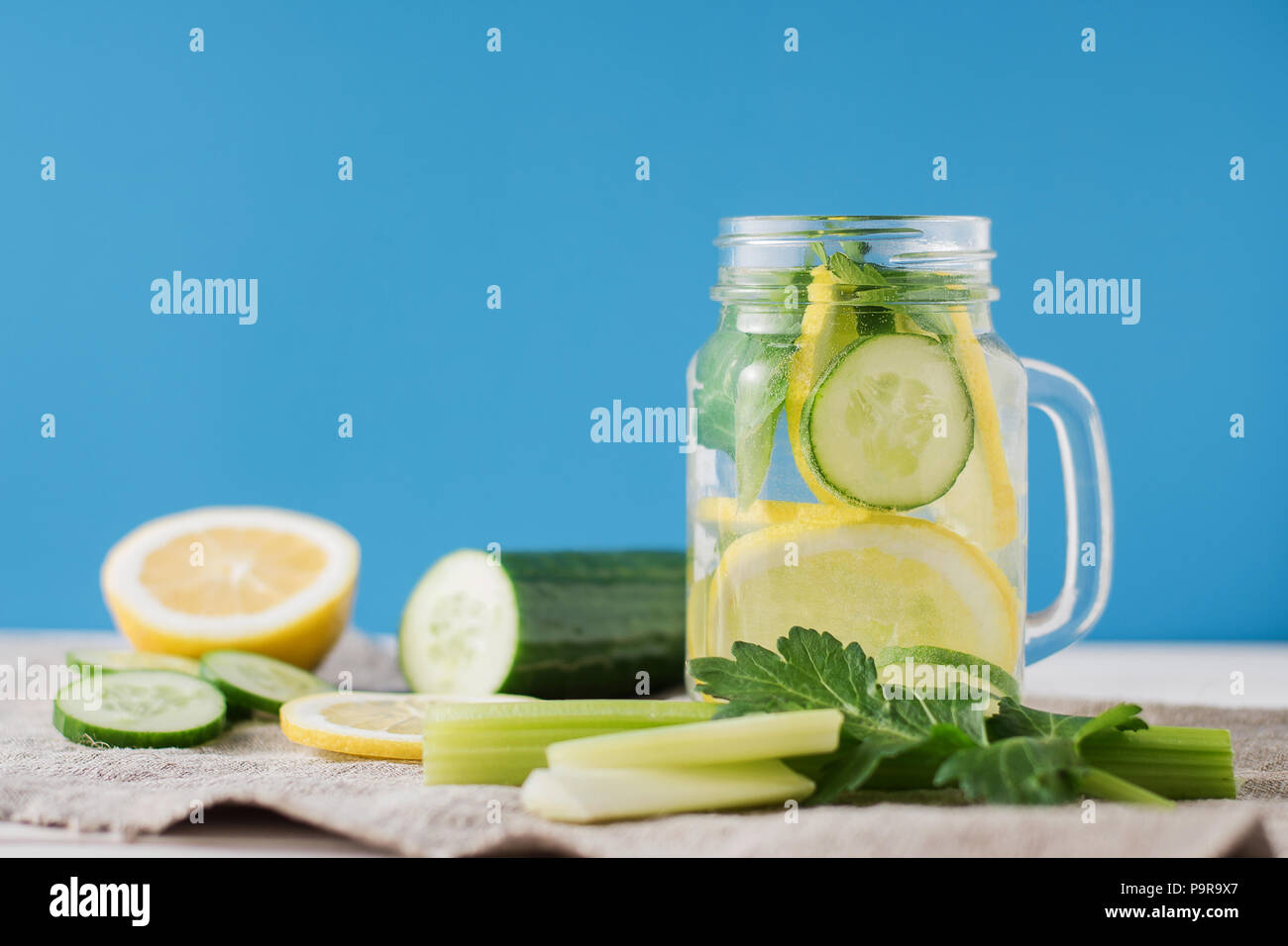 Detox water with cucumber and lemon on blue background Stock Photo - Alamy
