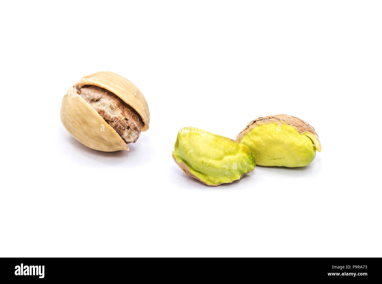 One open pistachio nuts, two without shells, isolated on white ...