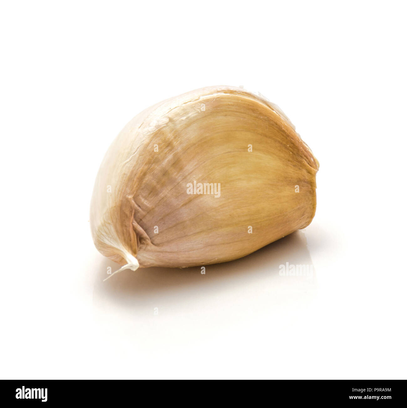 One whole unpeeled garlic clove isolated on white background Stock ...