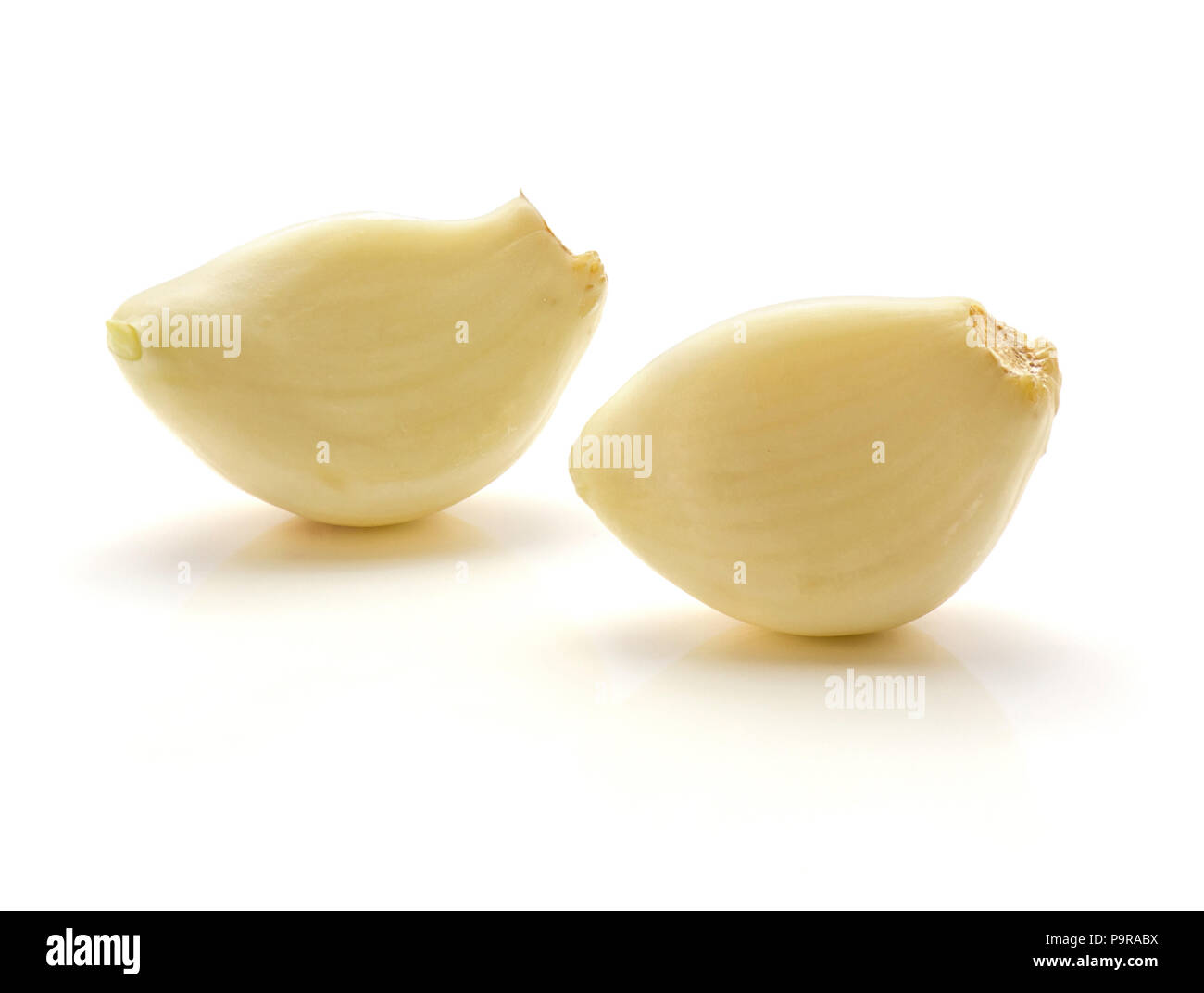 Two peeled garlic cloves isolated on white background Stock Photo - Alamy