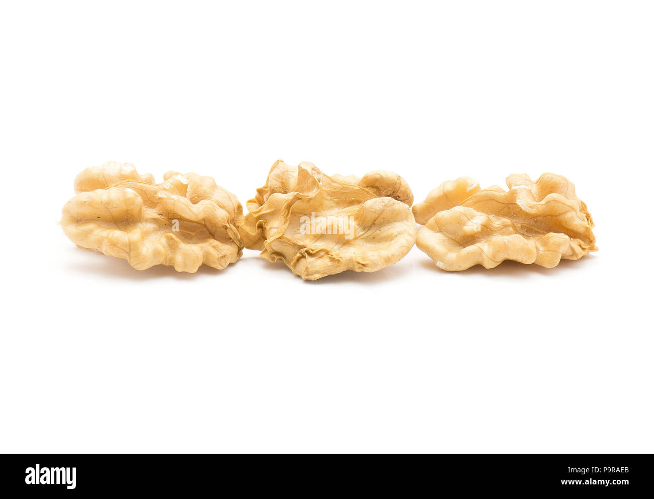 Three shelled walnuts in row isolated on white background Stock Photo ...