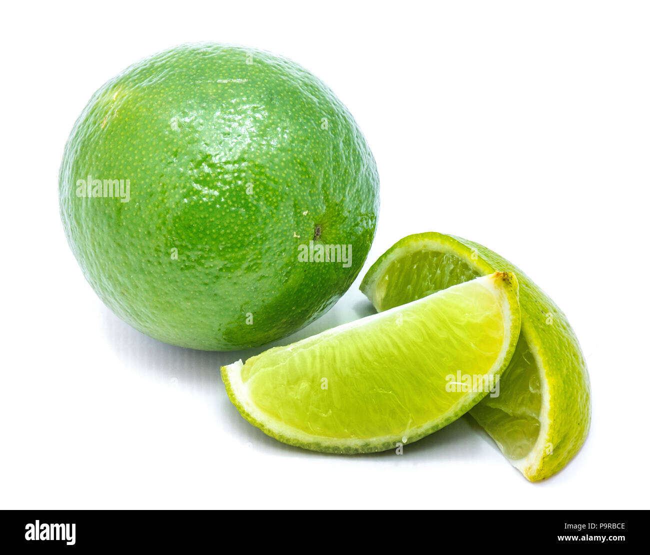 One whole lime and two lime slices isolated on white background Stock ...