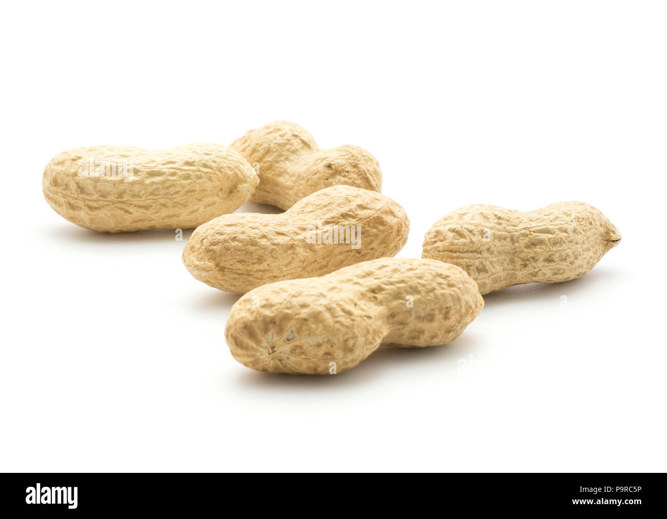 Unshelled peanuts isolated on white background five raw Stock Photo - Alamy
