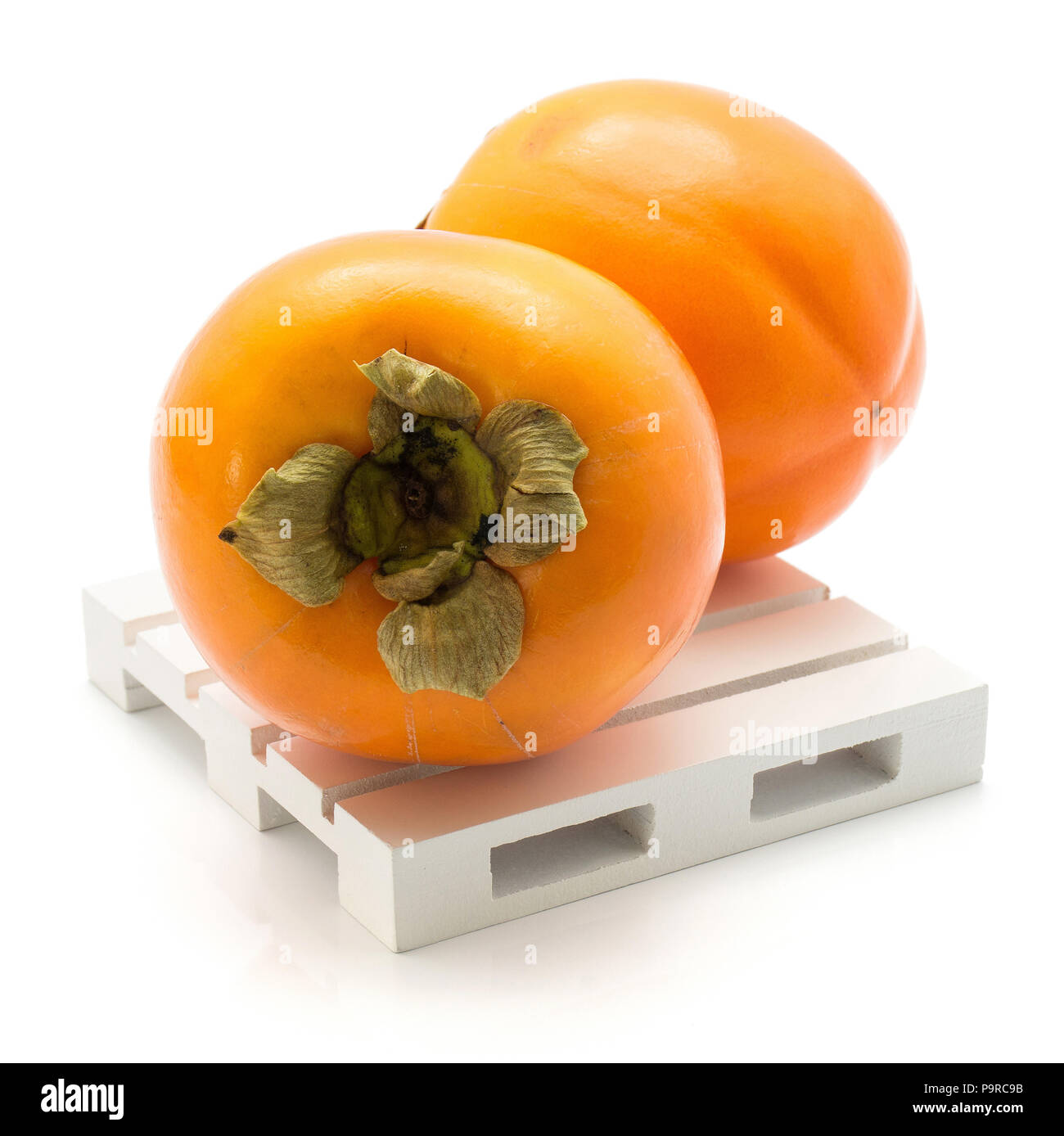Two persimmon Kaki on a pallet isolated on white background Stock Photo ...