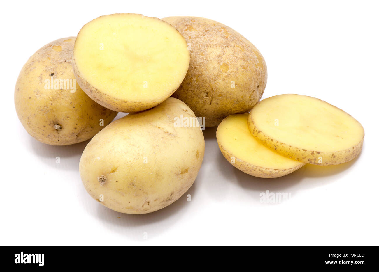 Three whole potatoes and slices isolated on white background Stock ...