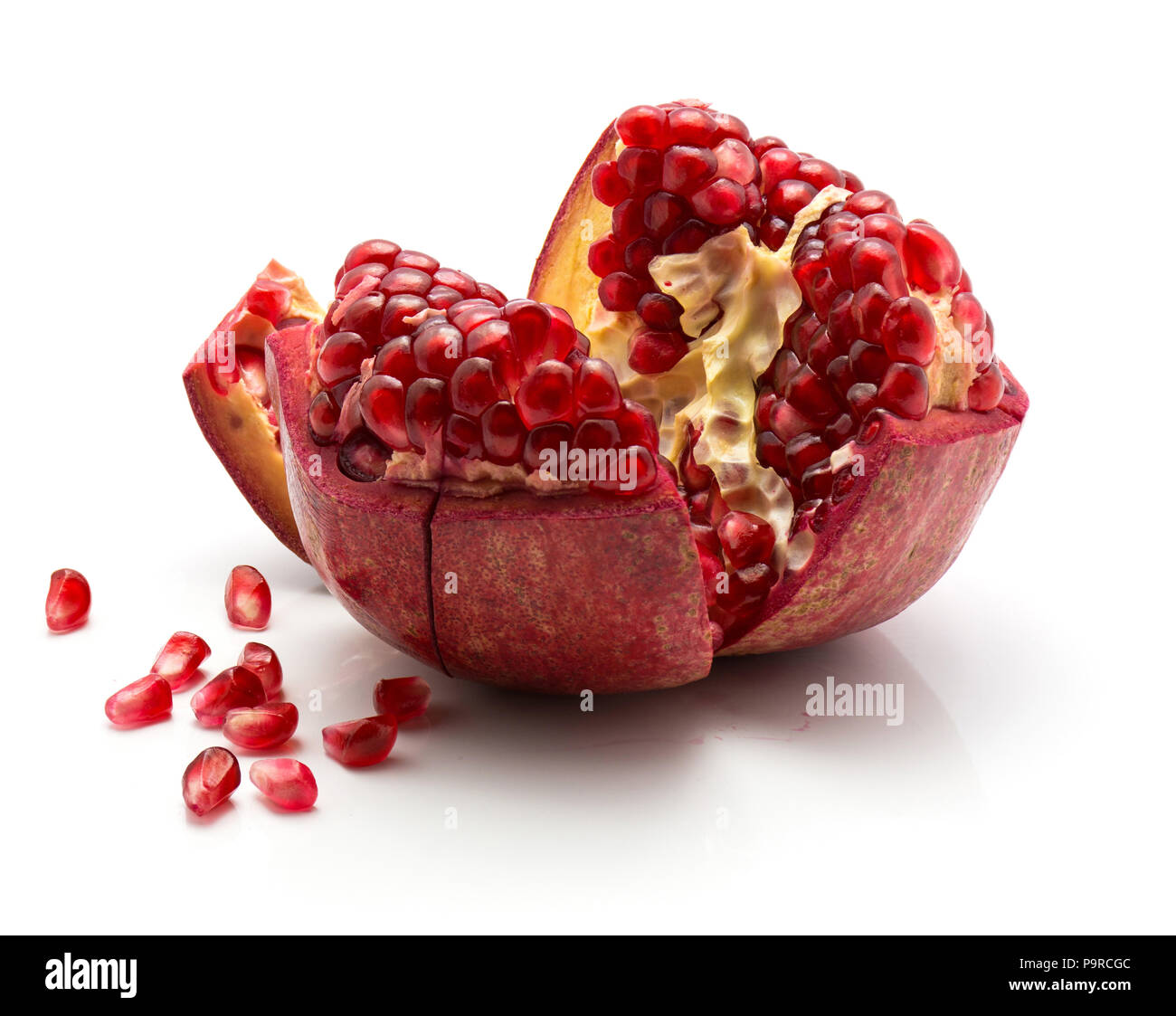 Open pomegranate with revealed grains isolated on white background ...