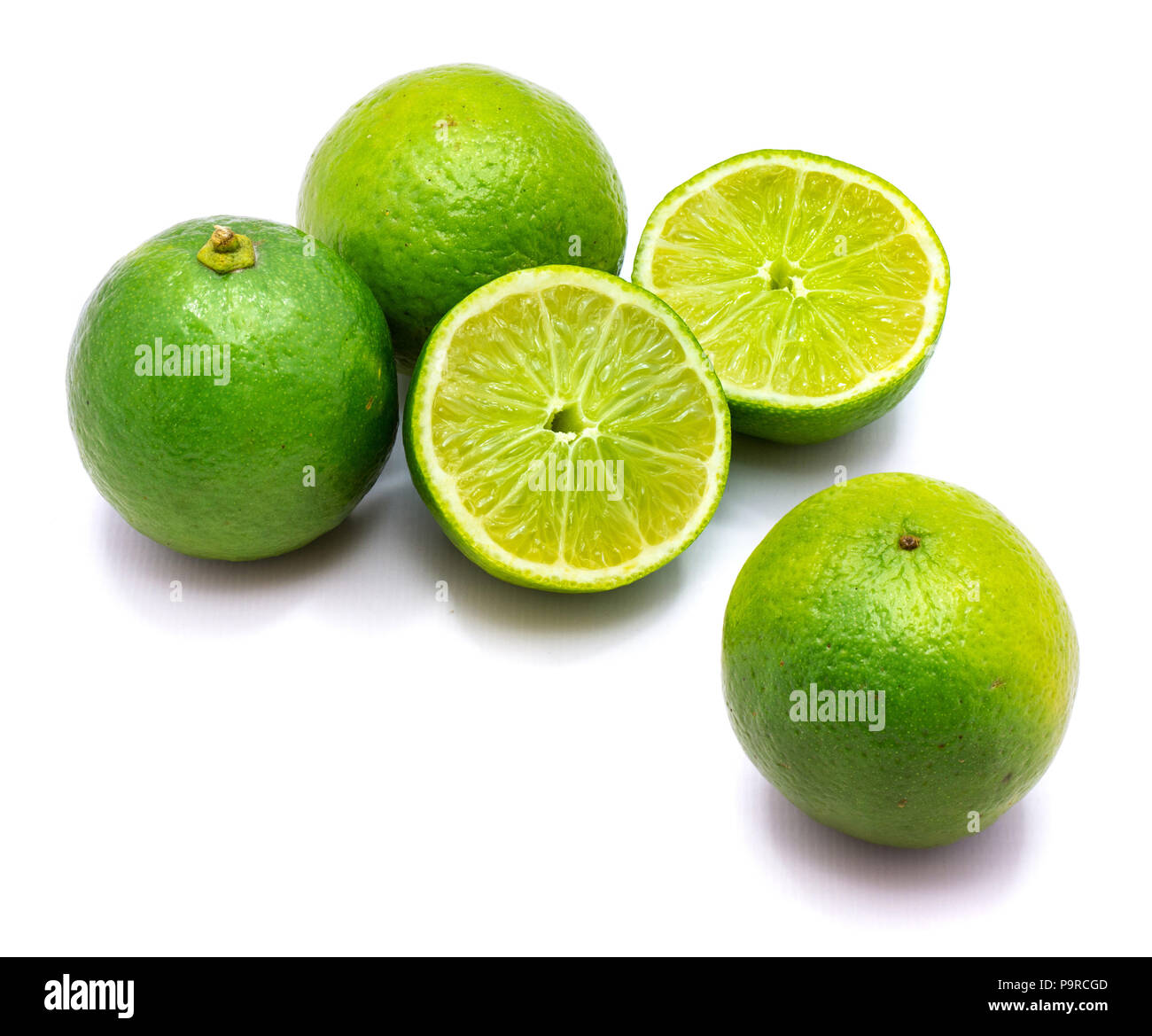 Group of whole limes and sliced halves isolated on white studio ...