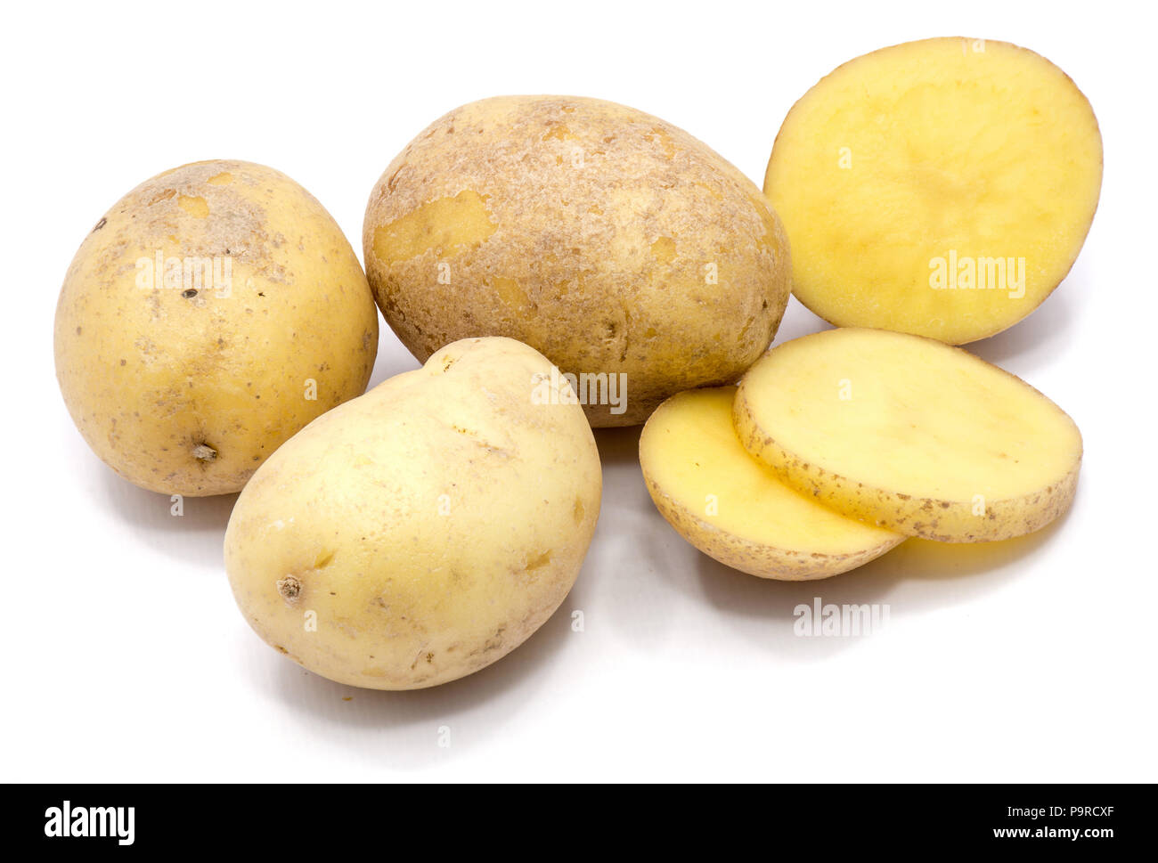 Three whole potatoes and slices isolated on white background Stock ...