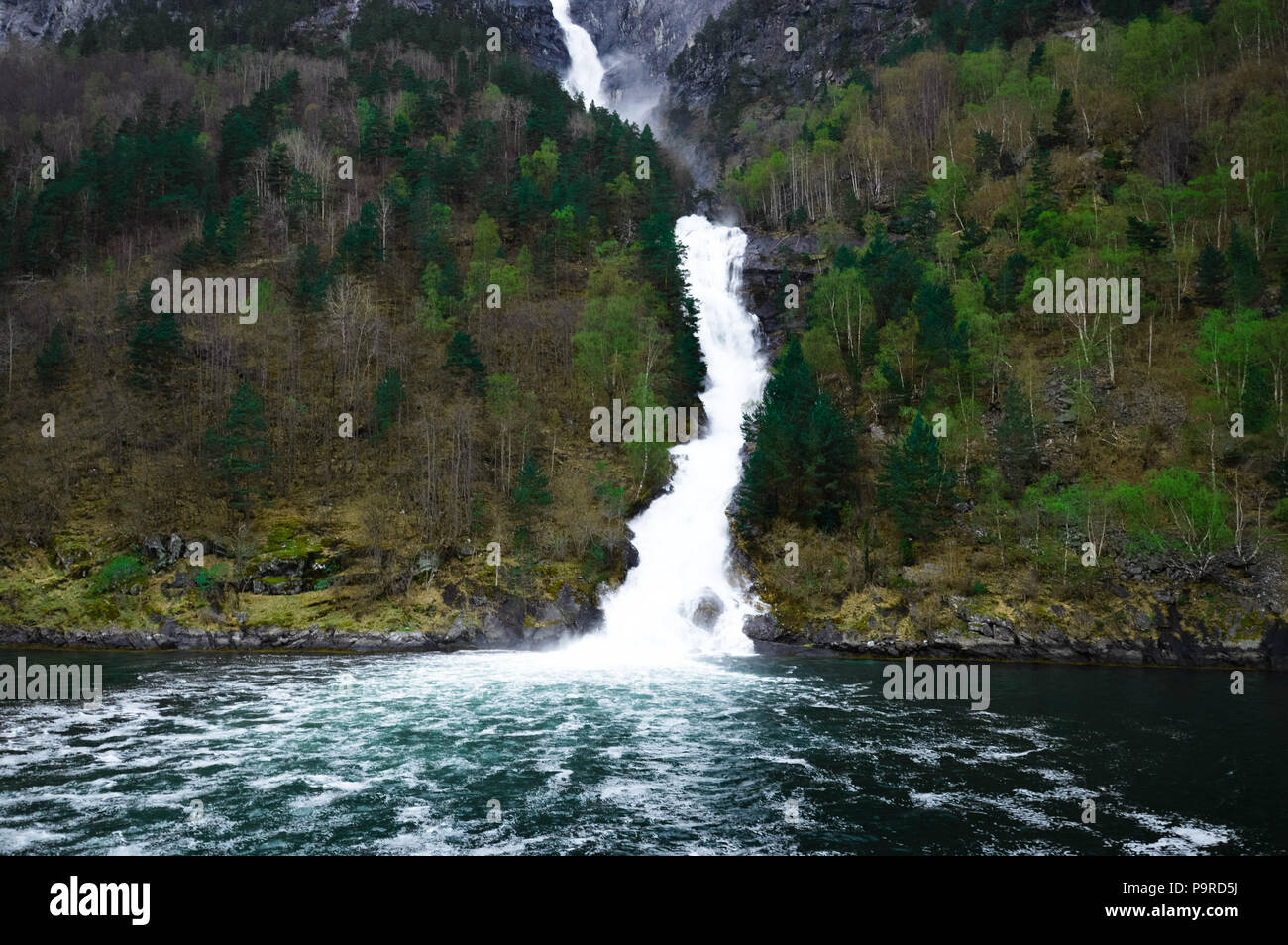 waterfall flows down among the mountains - Flam in Norway Stock Photo ...