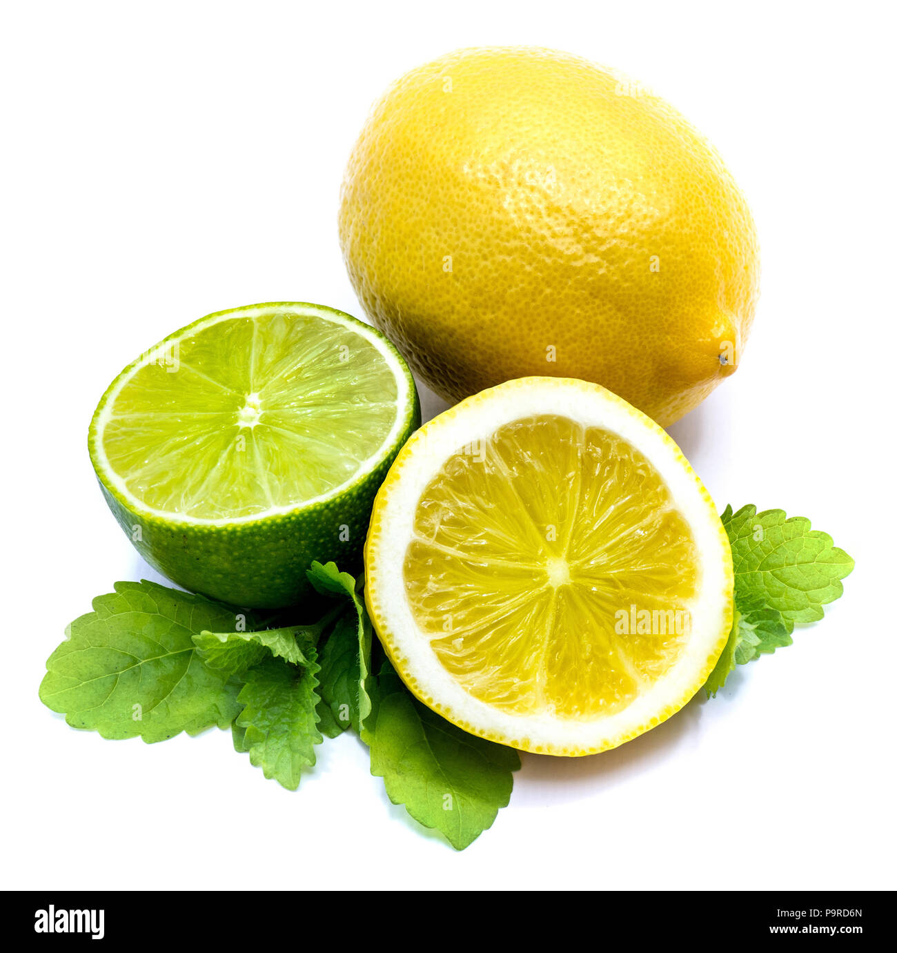 One whole yellow lemon, pair of lime and lemon halves on fresh green ...