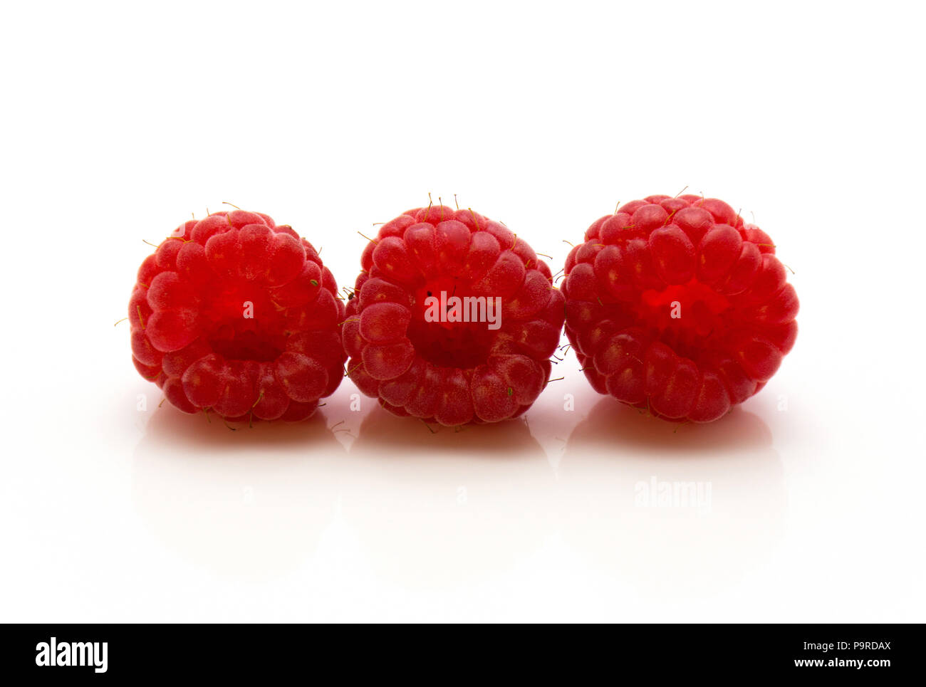 Three red raspberries in row isolated on white background Stock Photo ...