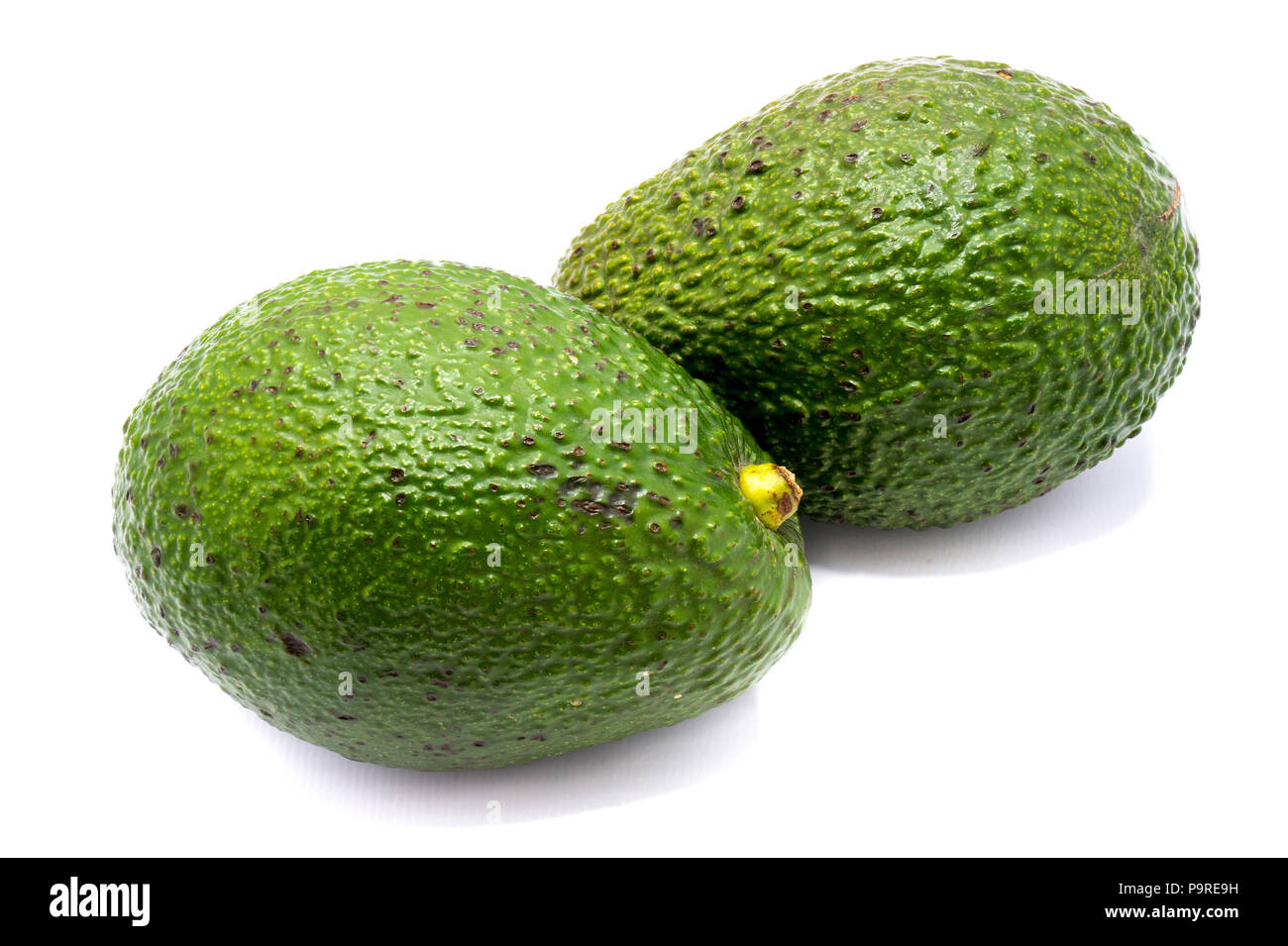 Two whole avocado (Persea americana, alligator pear) isolated on white ...