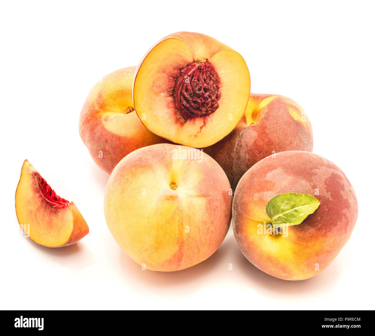Group of peaches, whole with a green leaf, one half with a stone, one ...