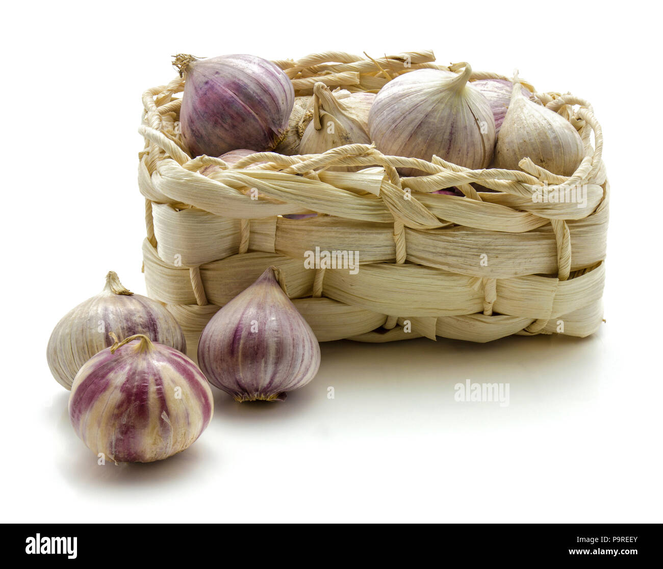 Solo pearl garlic in straw basket isolated on white background single ...