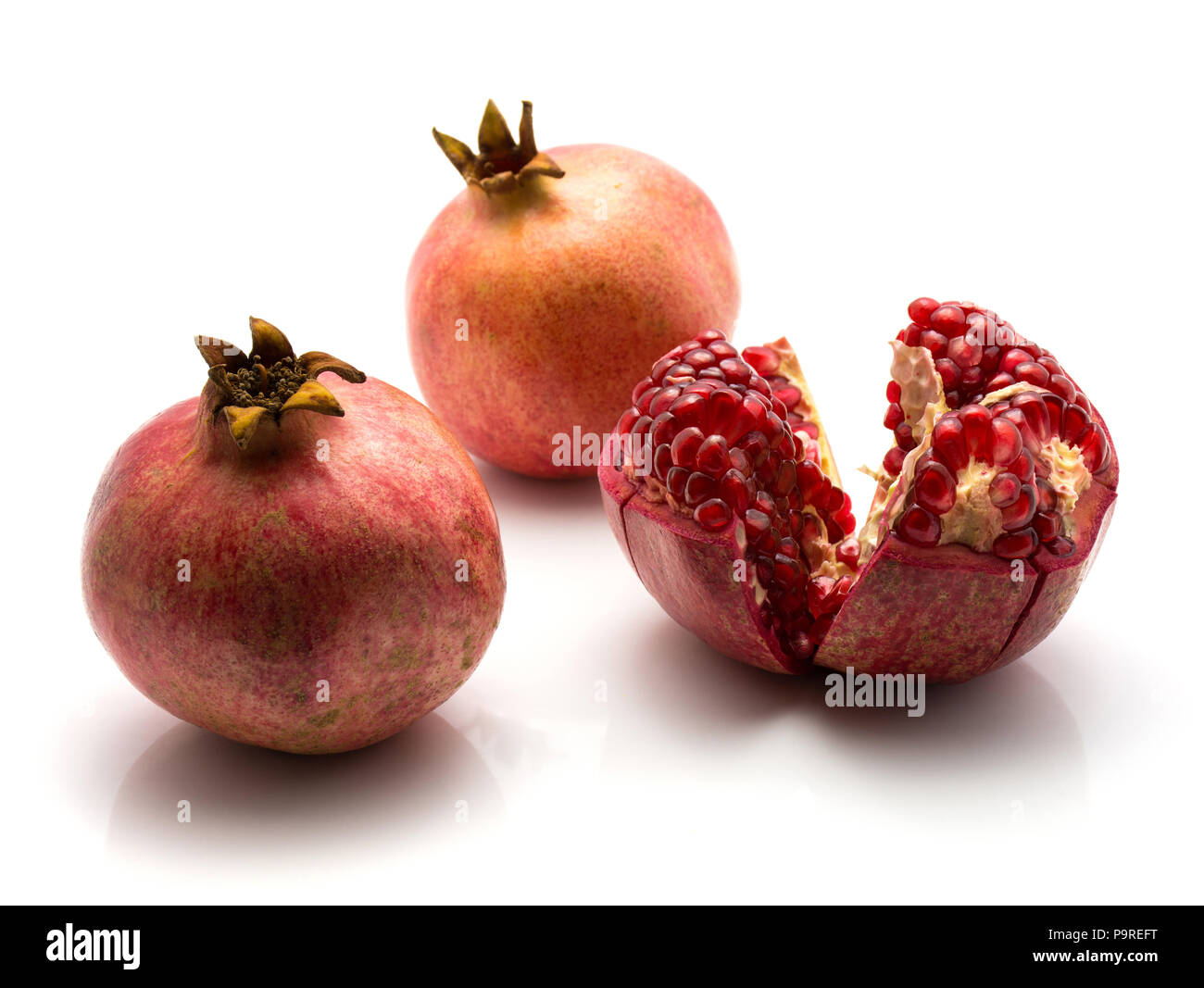 Pomegranate isolated on white background two whole and one open Stock ...