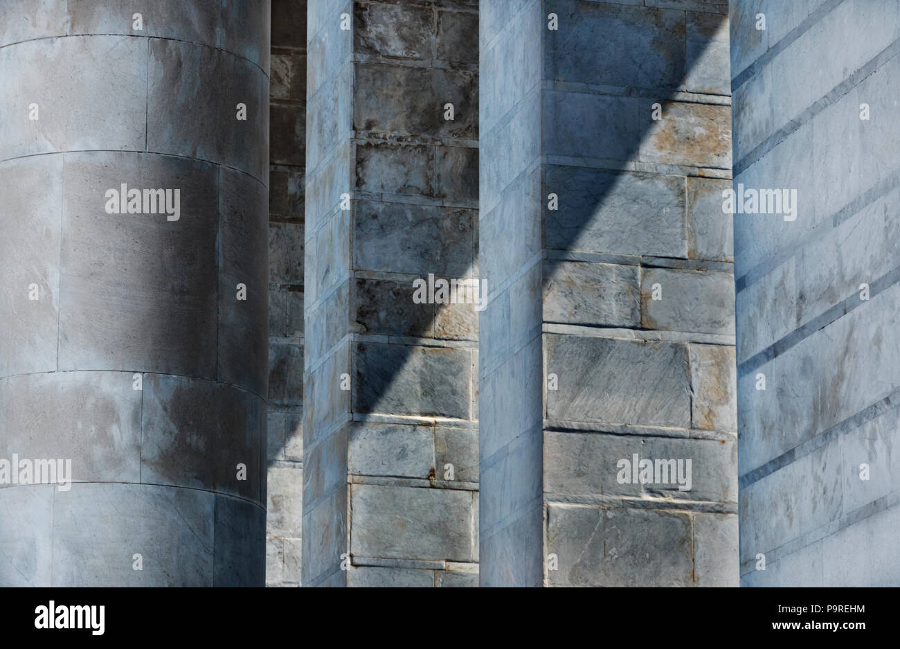 Building section ,several pillars and a column covered of marble ,light ...