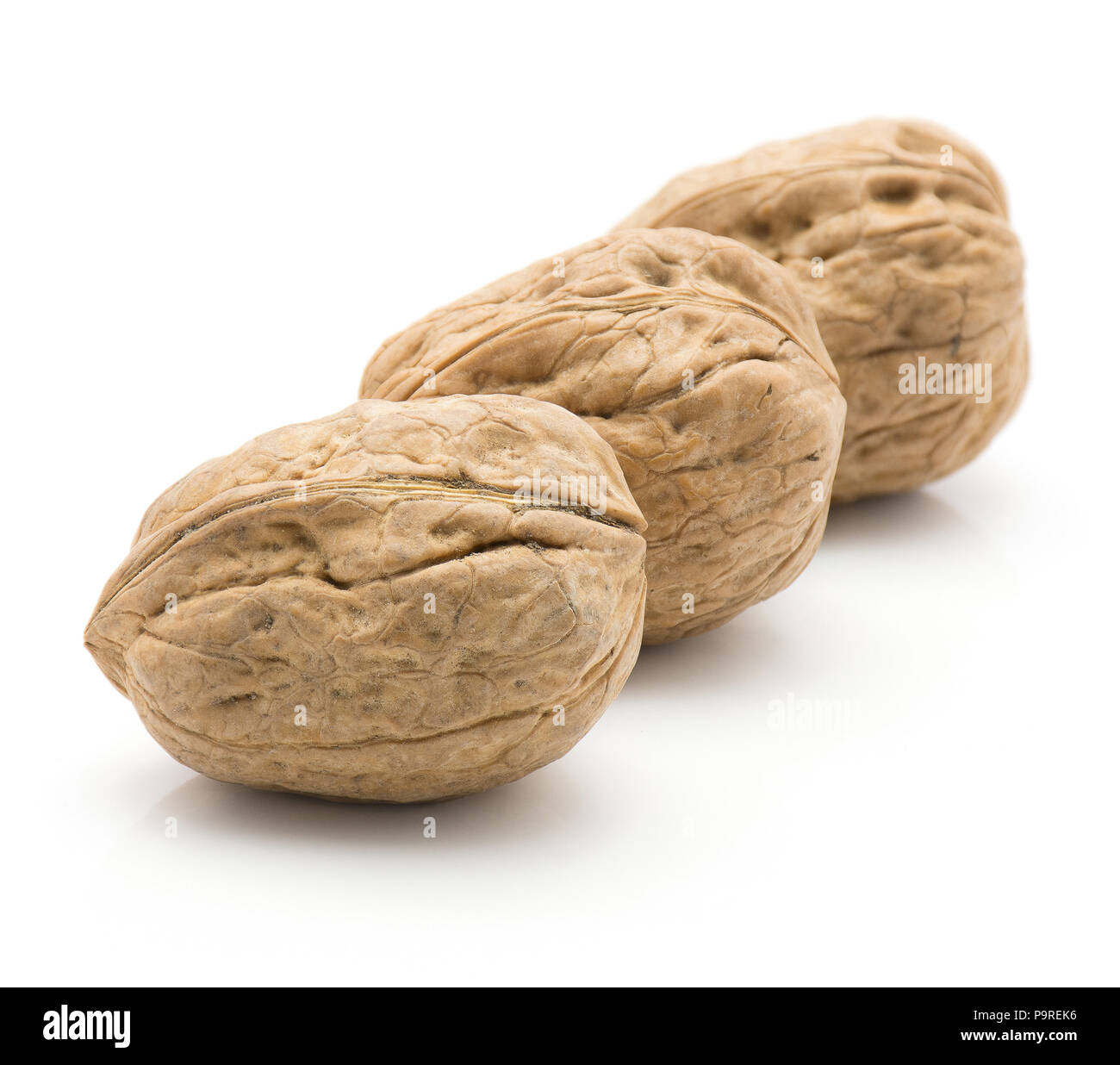 Unshelled walnuts isolated on white background three whole in row Stock ...