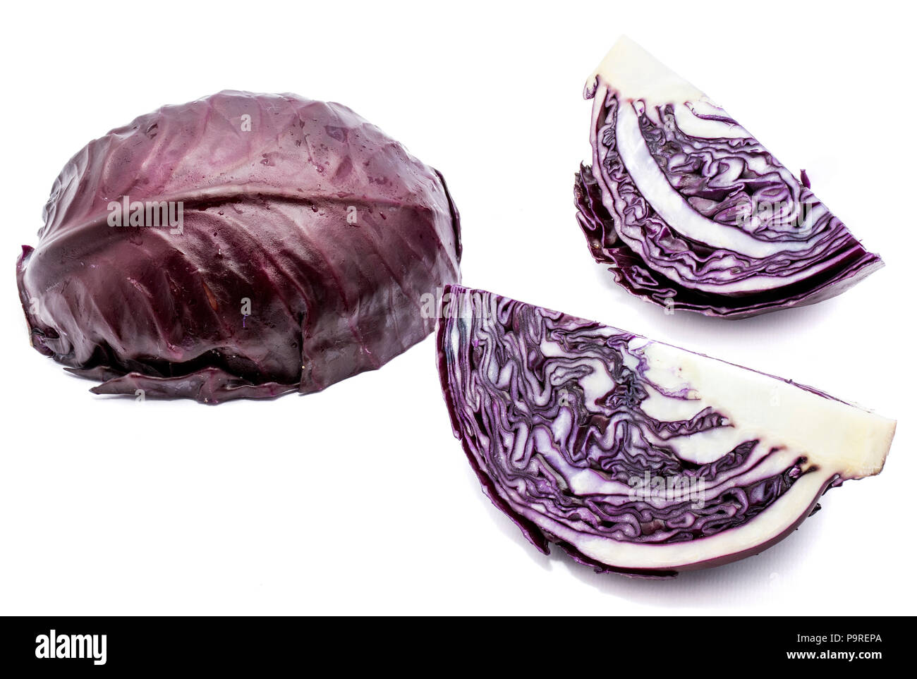 Two sliced quarters of purple cabbage and one half isolated on white ...