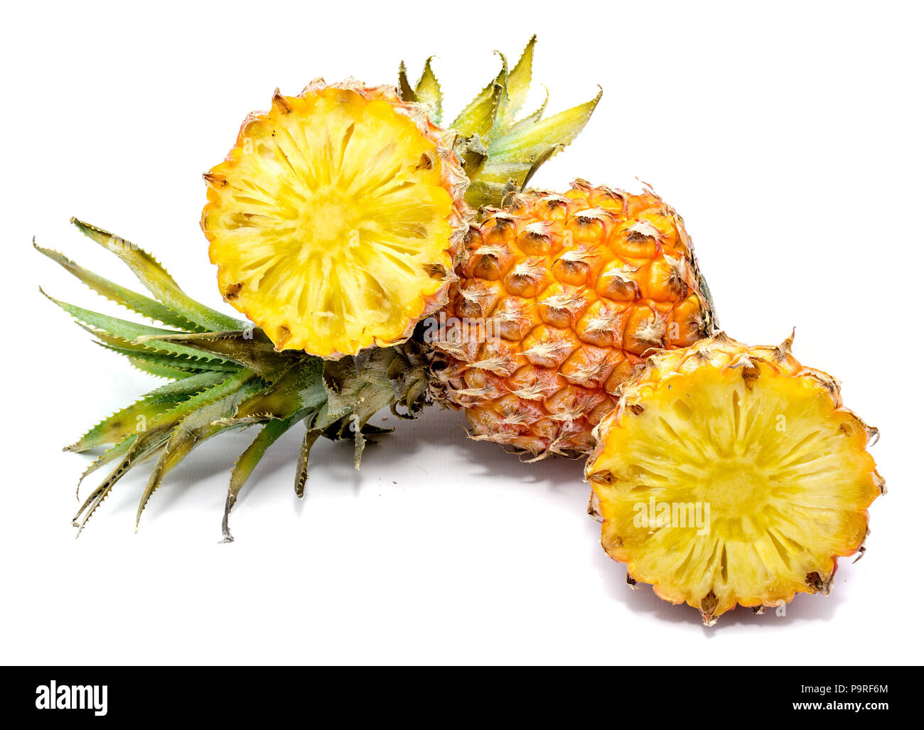 One whole pineapple and its sliced halves isolated on white background ...
