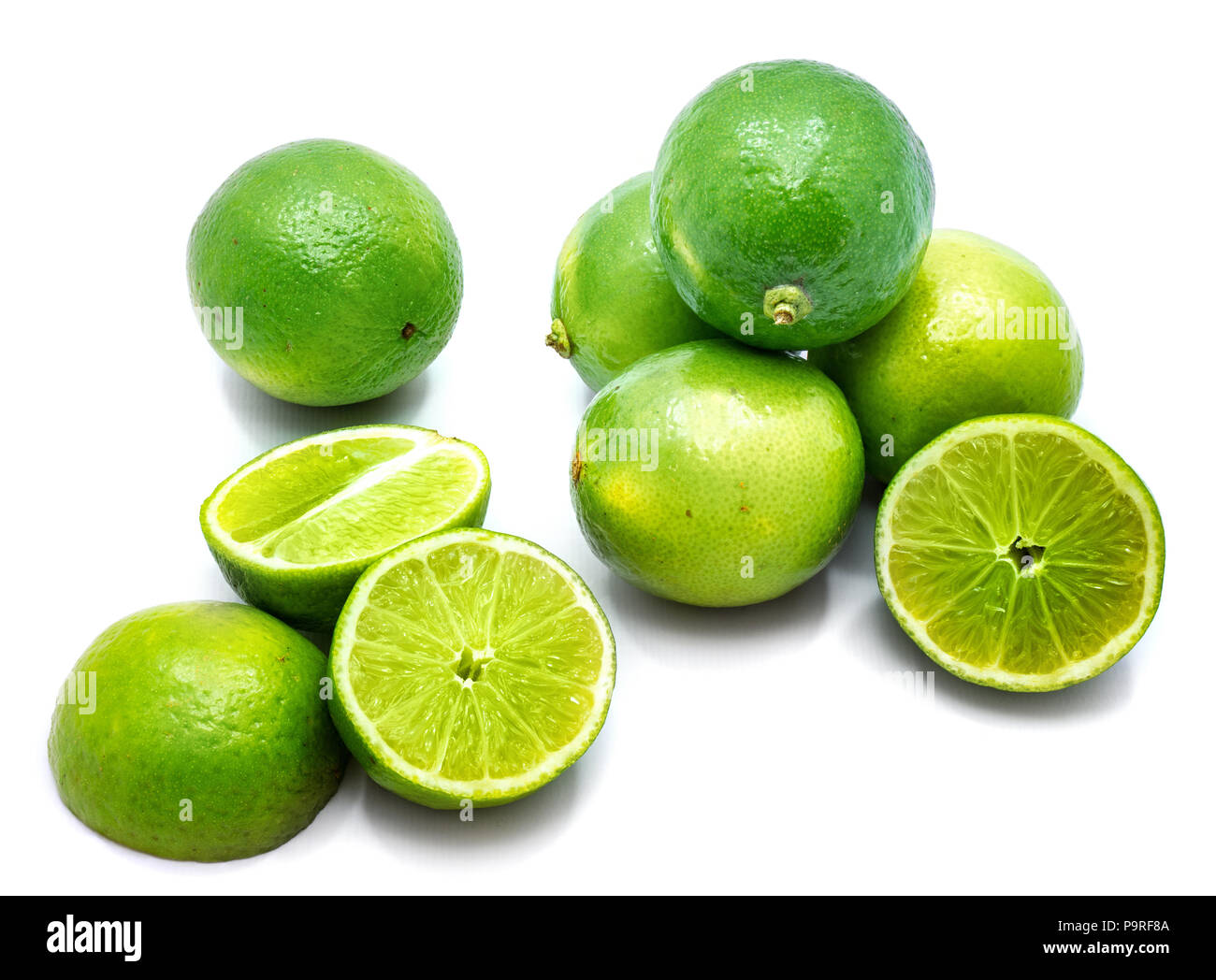 Group of whole and lime halves isolated on white studio background ...