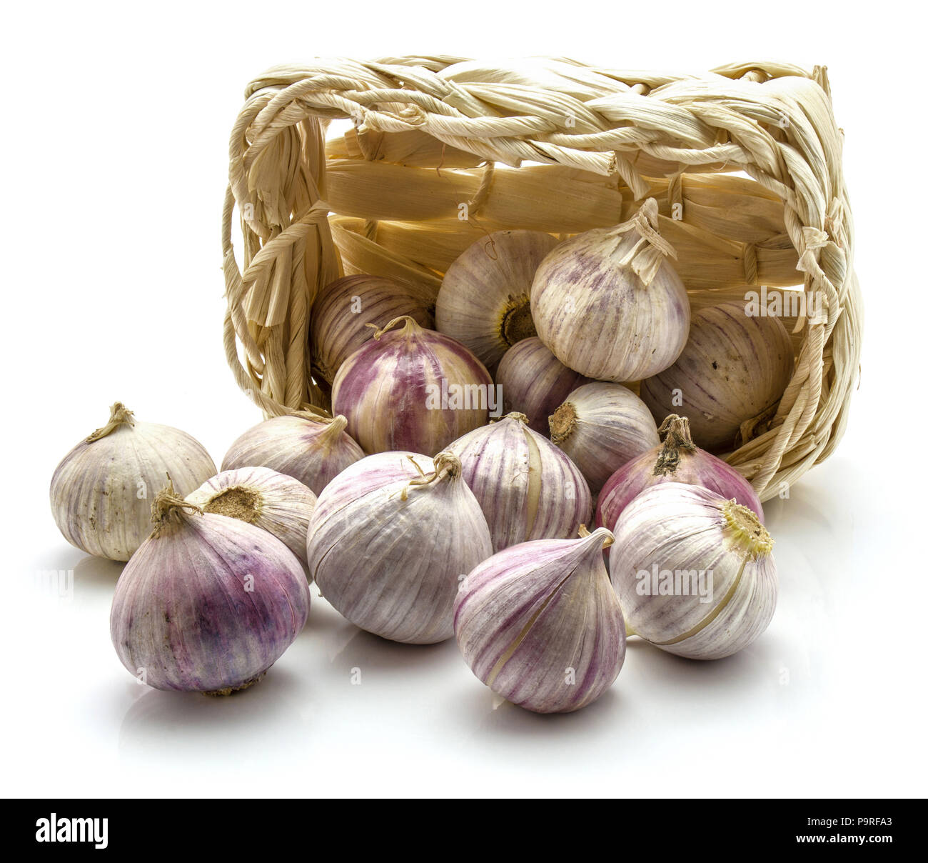 Scattered solo pearl garlic from a straw basket isolated on white ...