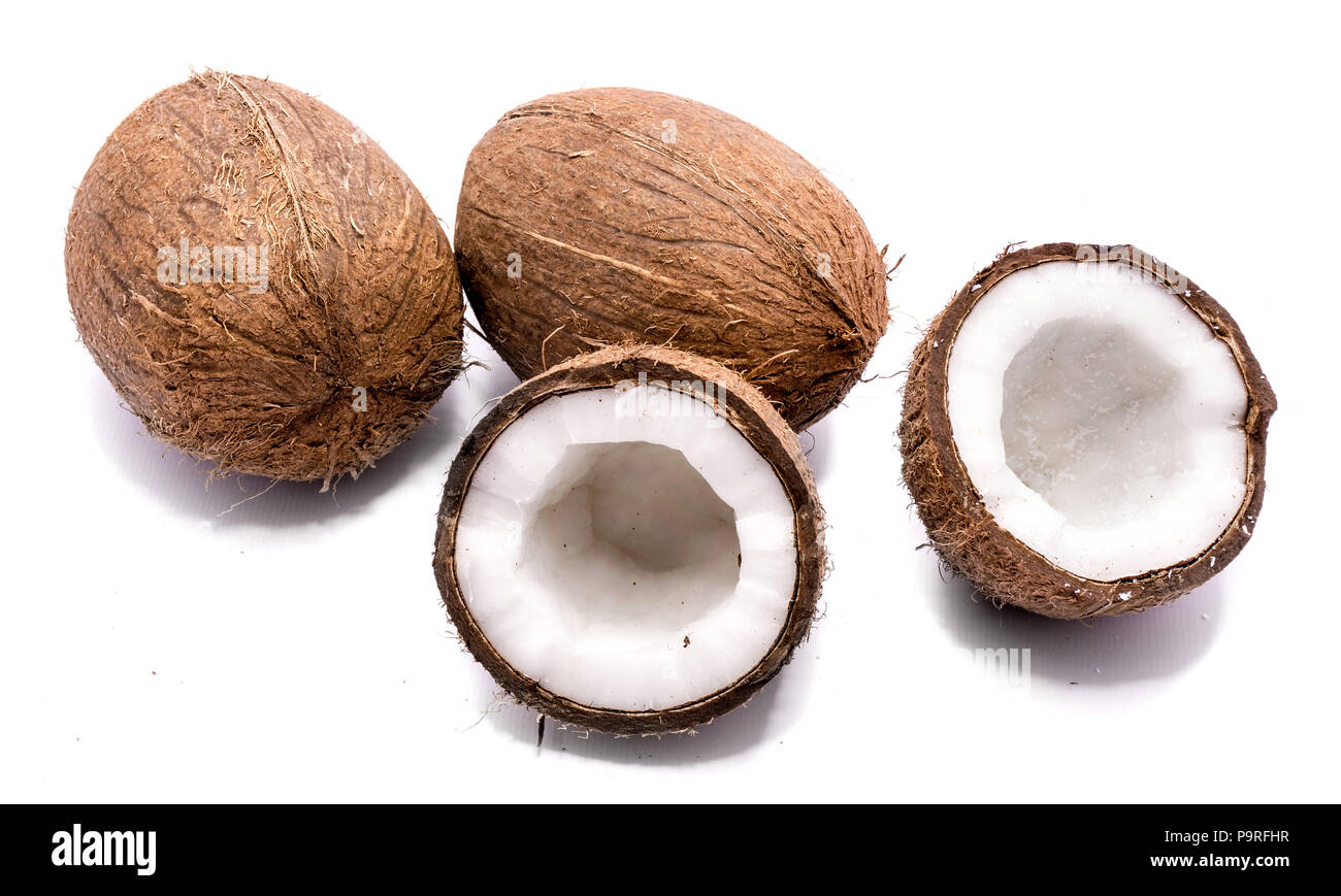 Two whole coconuts and two cracked coconut halves isolated on white ...