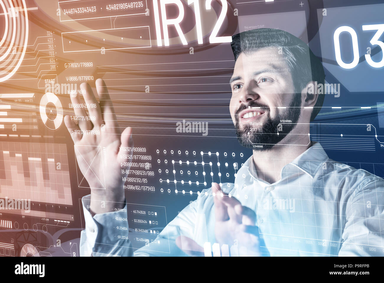 Cheerful man. Clever computer support specialist smiling while touching ...