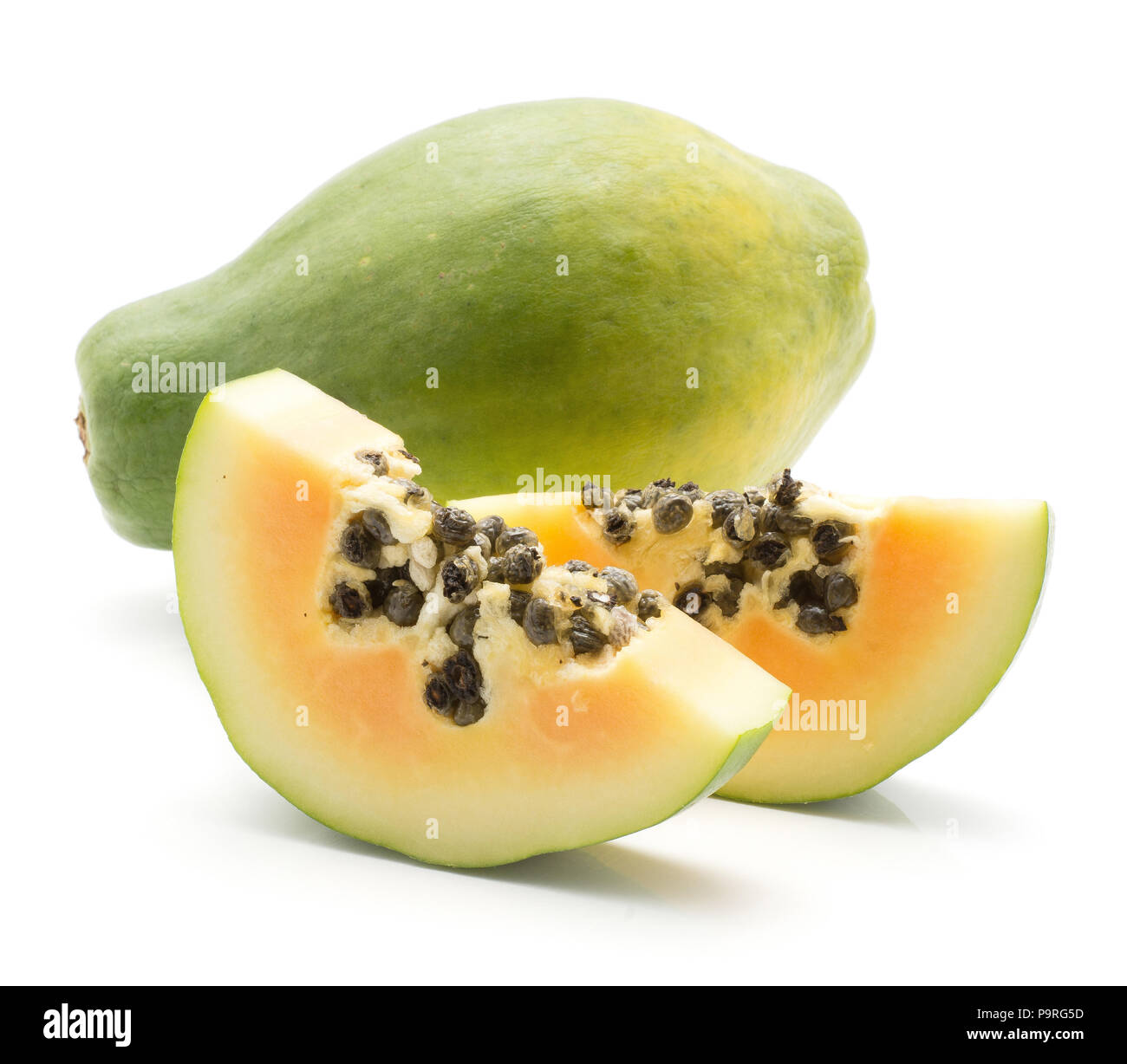 Green papaya (pawpaw, papaw) one whole and two slices with seeds ...