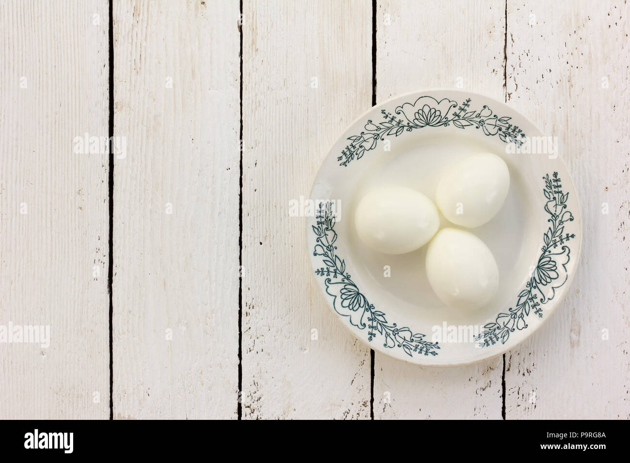 boiled chicken eggs without the shell on a ceramic saucer on a white ...