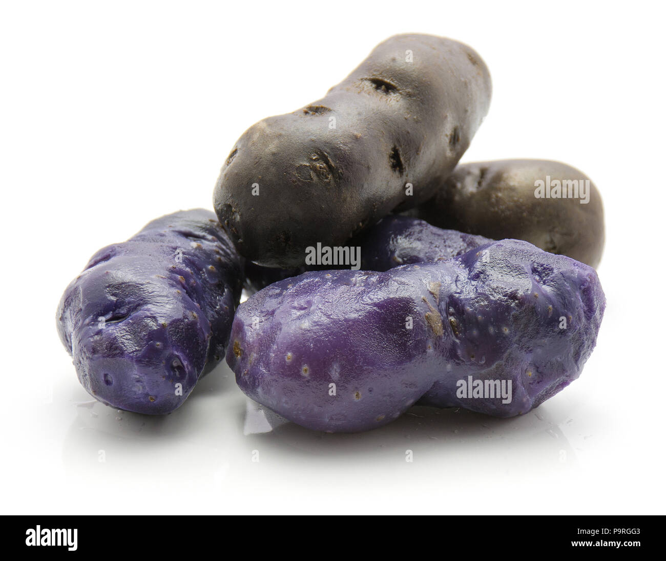 Boiled vitelotte potatoes isolated on white background three peeled and ...